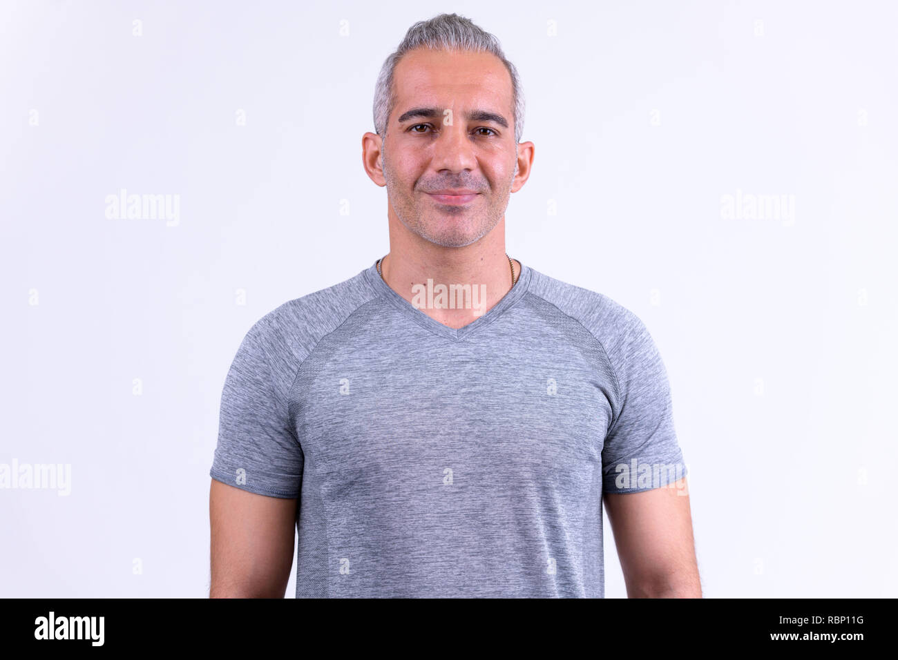 Happy Persian man smiling and ready for gym against white background ...
