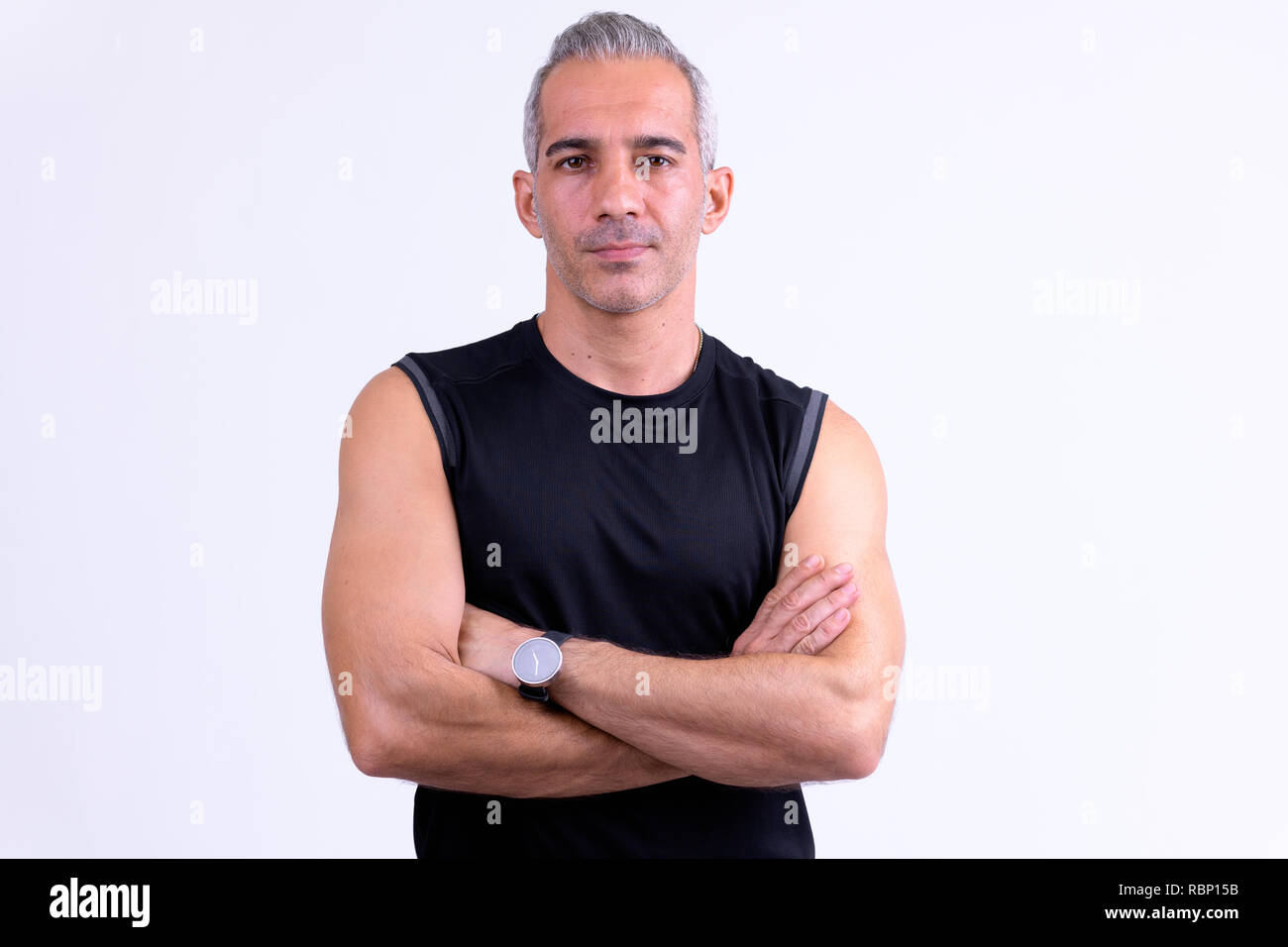 Handsome Persian man with arms crossed ready for gym against white ...