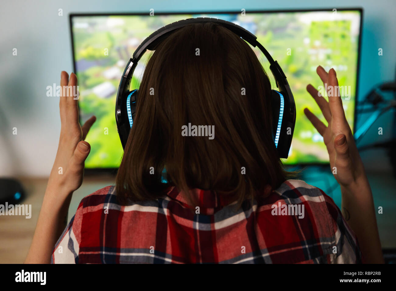 Back view of a nervous angry young woman gamer playing online computer ...