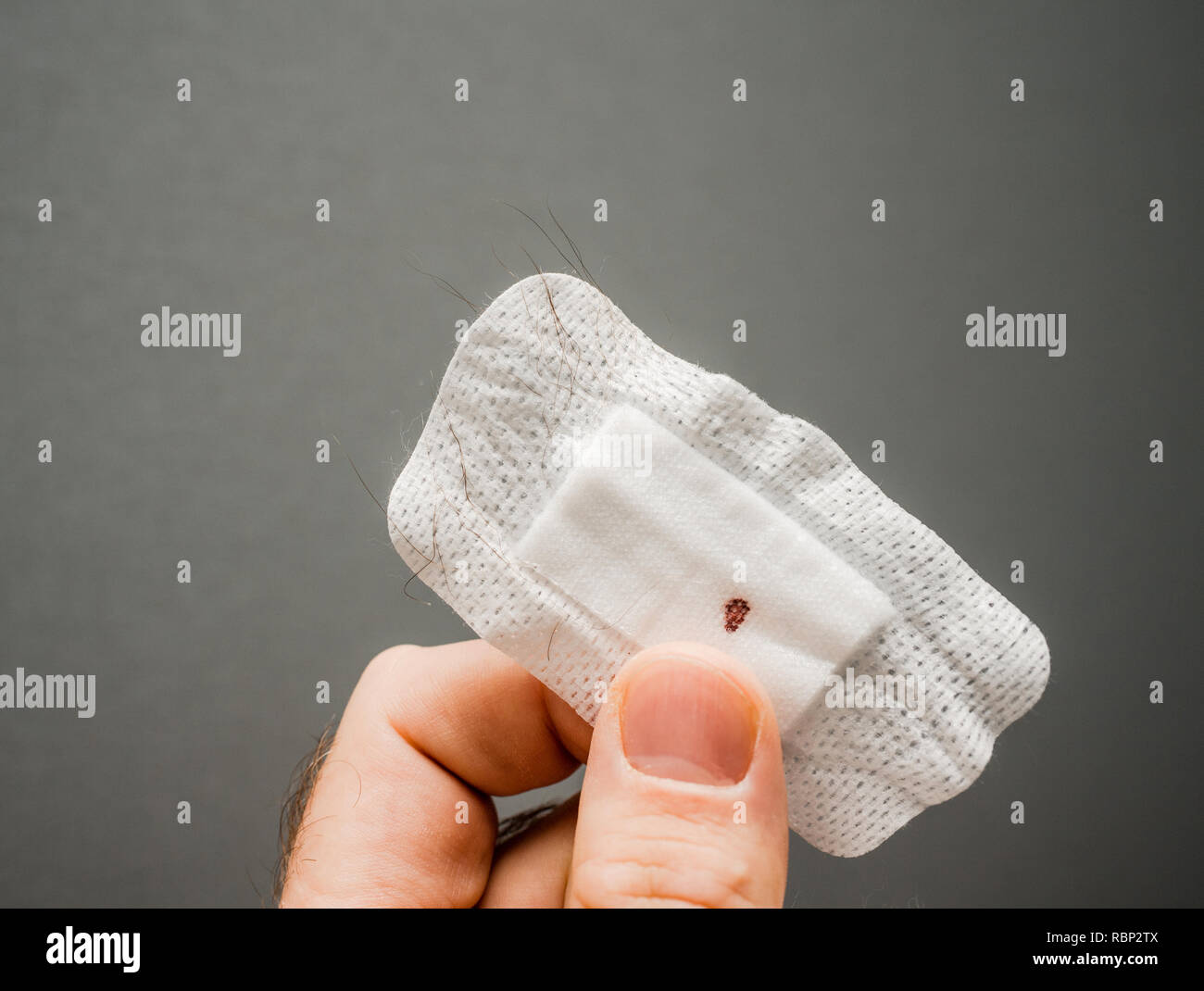 Macro shot of band aid in male hand with bandage containing epilated ...