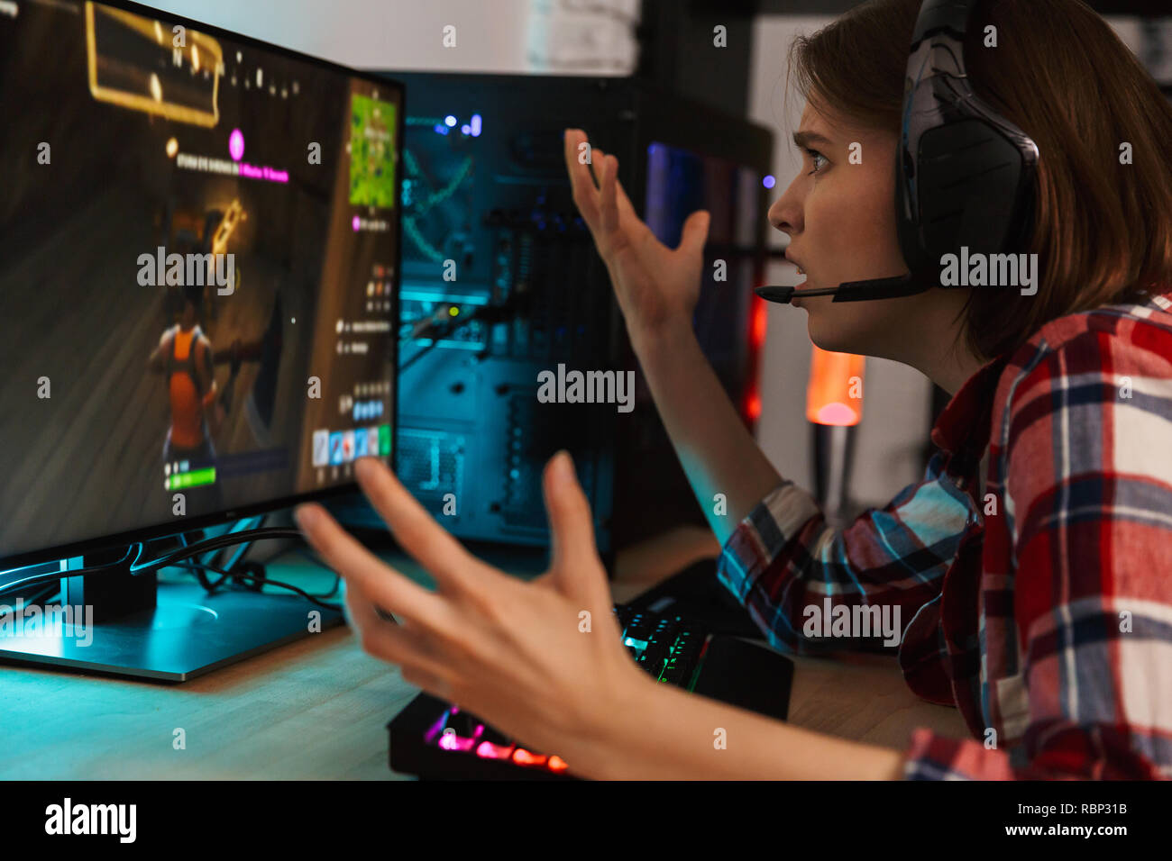 Nervous angry young woman gamer playing online computer games at the ...