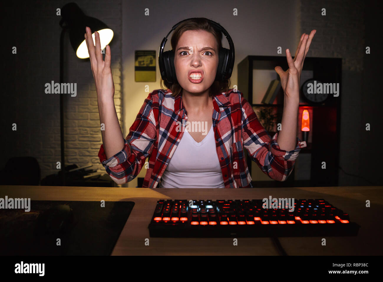 Nervous angry young woman gamer playing online computer games at the ...