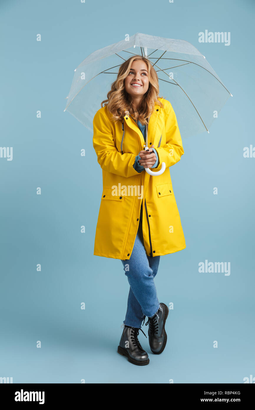 Full length image of european woman 20s wearing yellow raincoat ...
