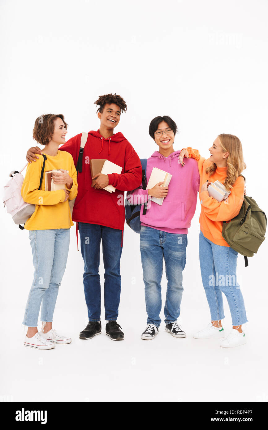 Group of cheerful teenagers isolated over white background, carrying ...