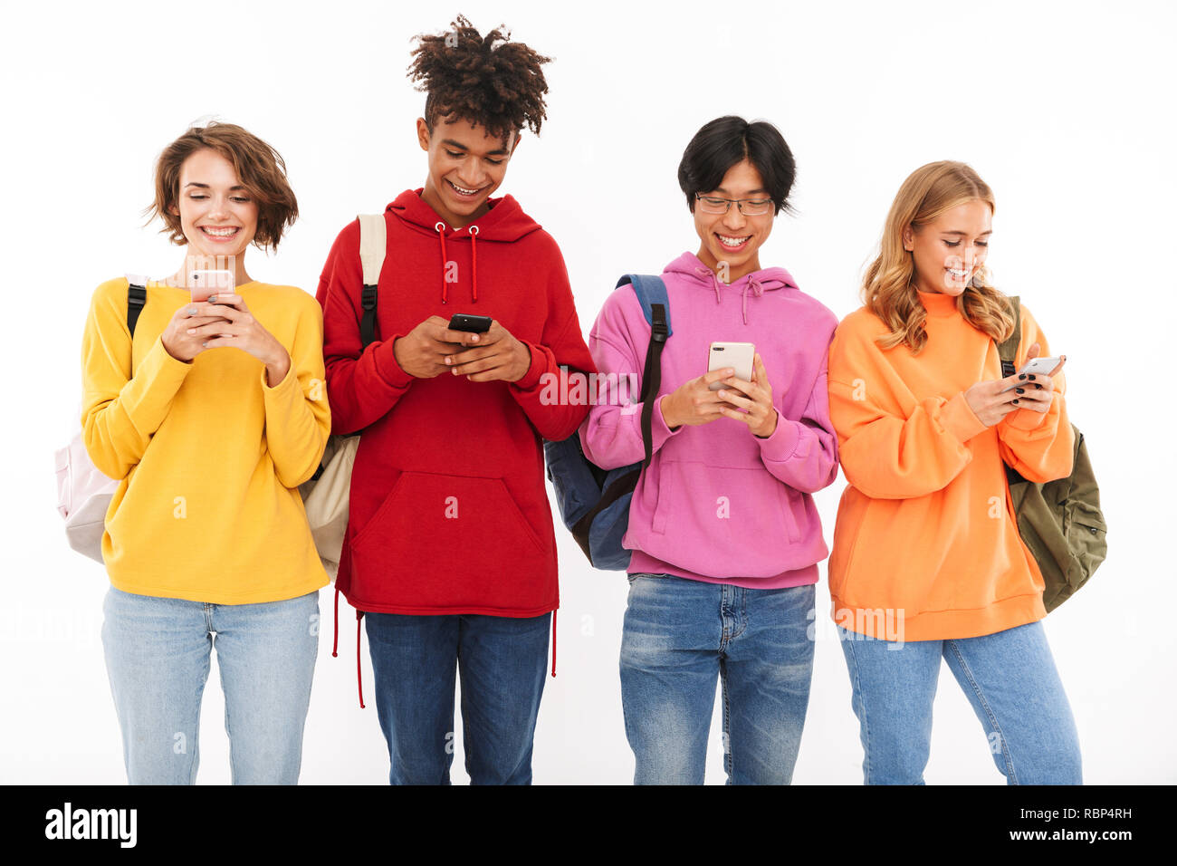 Group of cheerful teenagers isolated over white background, carrying ...