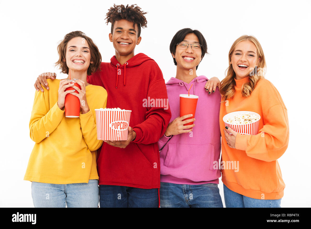 Group of cheerful multiracial friends watching a movie, eating popcorn ...