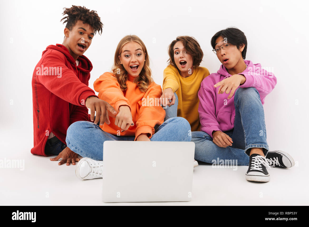 Group of cheerful teenagers isolated over white background, looking at ...