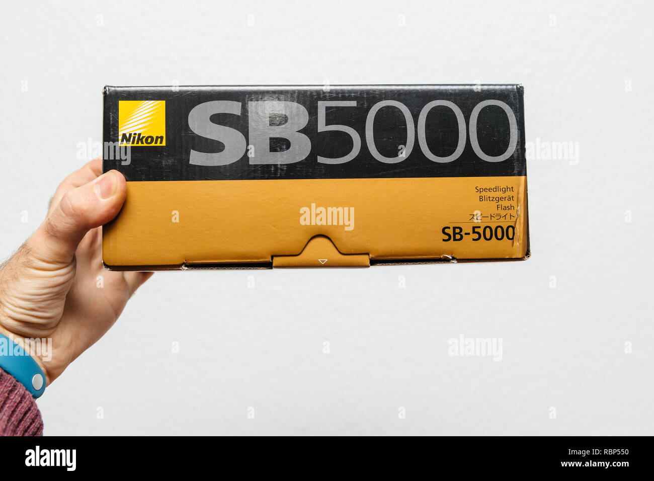 PARIS, FRANCE - JAN 23, 2018: Man holding against gray background a box ...