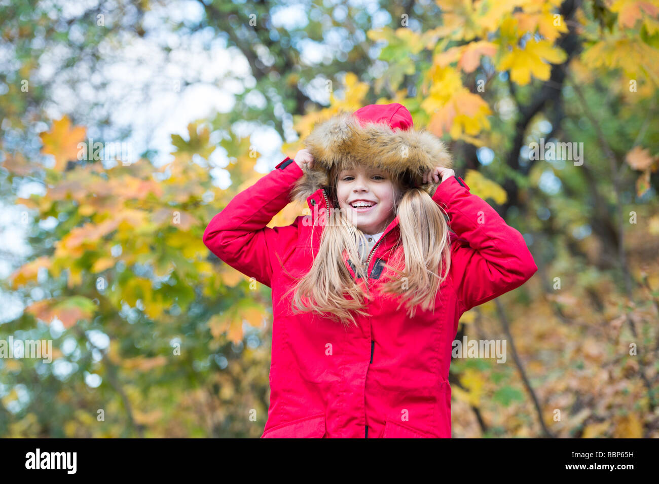 Hide above cozy hood or cape. Child blonde long hair walking in warm ...