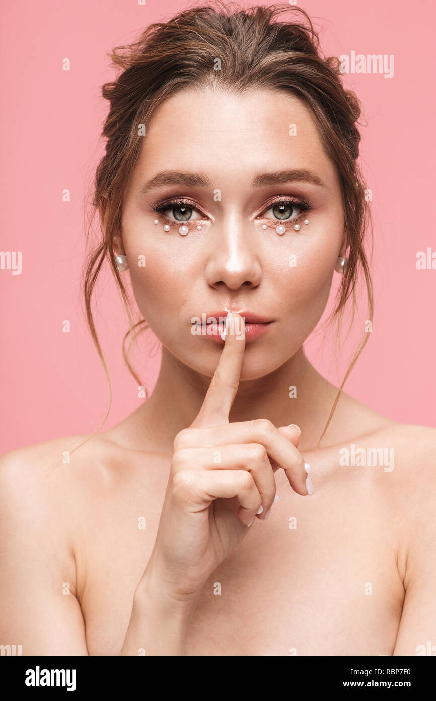 Image of a beautiful young woman posing isolated over pink wall ...