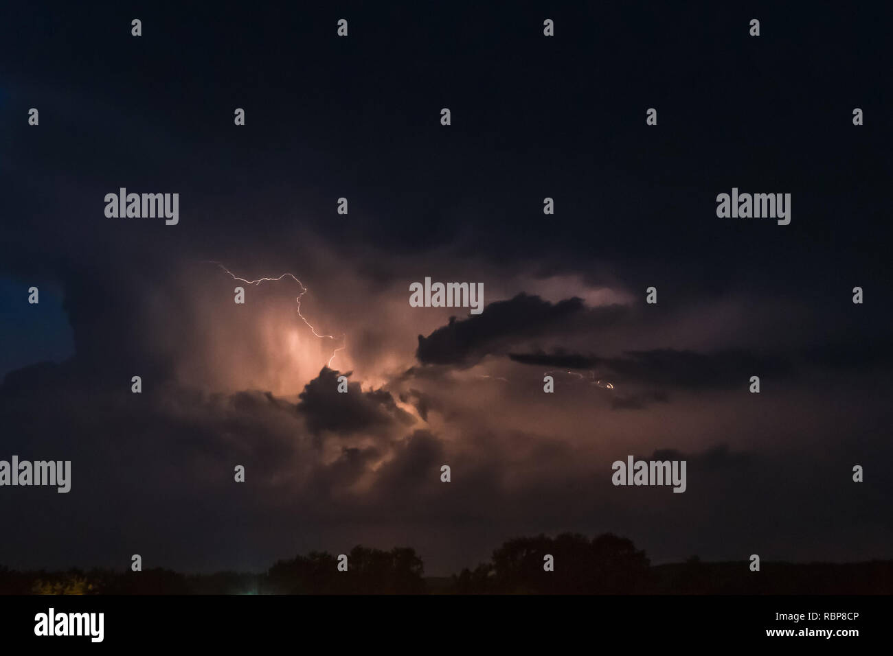 flash of lightning on a heavy cloudy background bringing thunder bolts ...