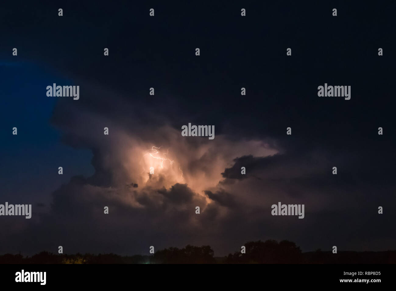 flash of lightning on a heavy cloudy background bringing thunder bolts ...