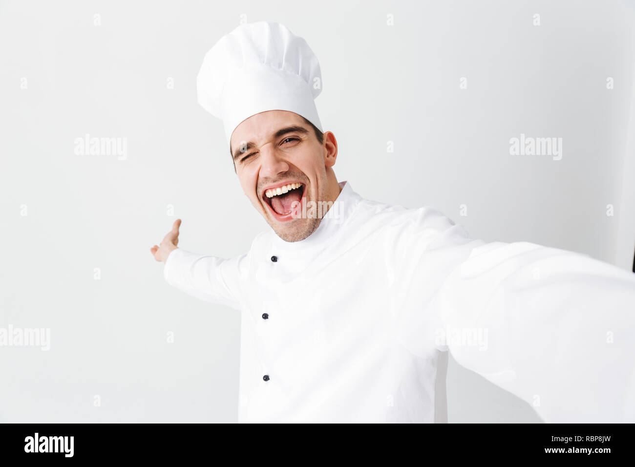 Happy chef cook wearing uniform standing isolated over white background ...