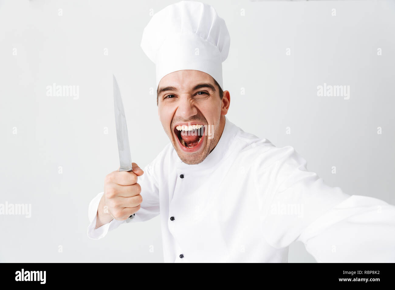Happy chef cook wearing uniform standing isolated over white background ...
