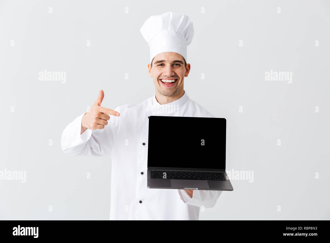 Cheerful chef cook wearing uniform standing over white background ...