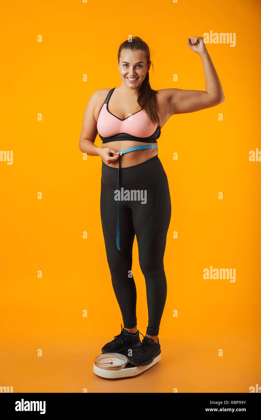 Full length portrait of a satisfied overweight young woman wearing ...