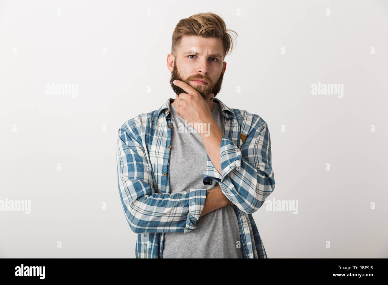 Image of a handsome young thinking man standing isolated over white ...