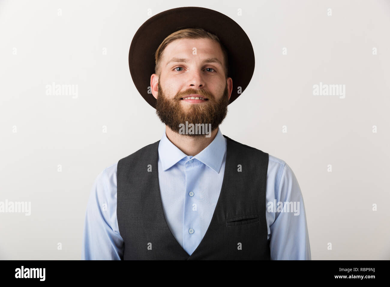 Image of a handsome young bearded man standing isolated over white wall ...