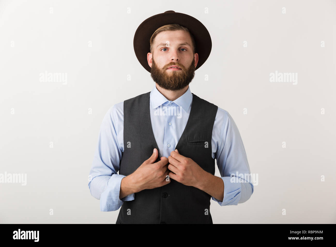 Image of a handsome young bearded man standing isolated over white wall ...