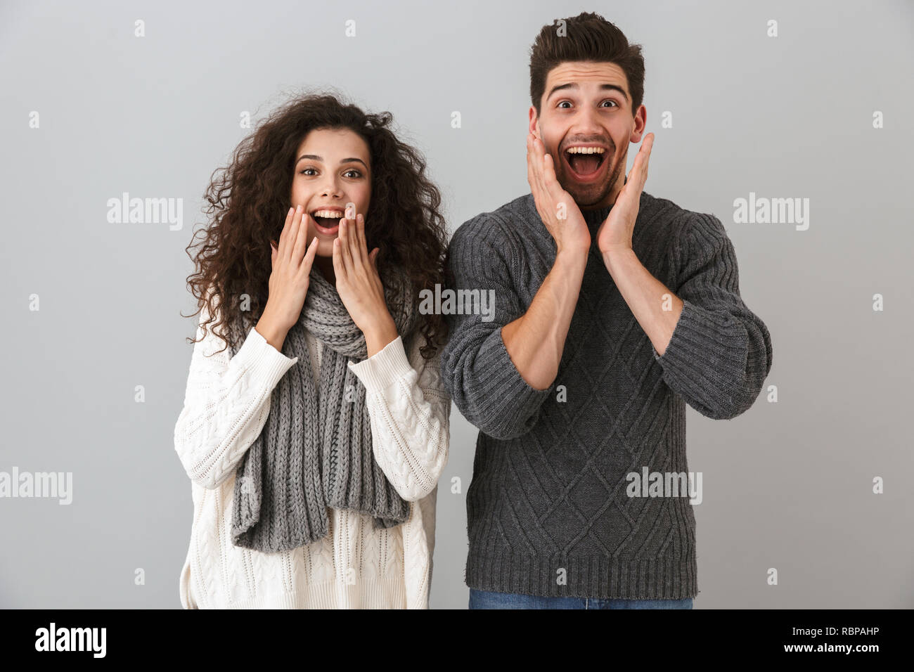 Portrait of joyous couple man and woman screaming and touching face ...