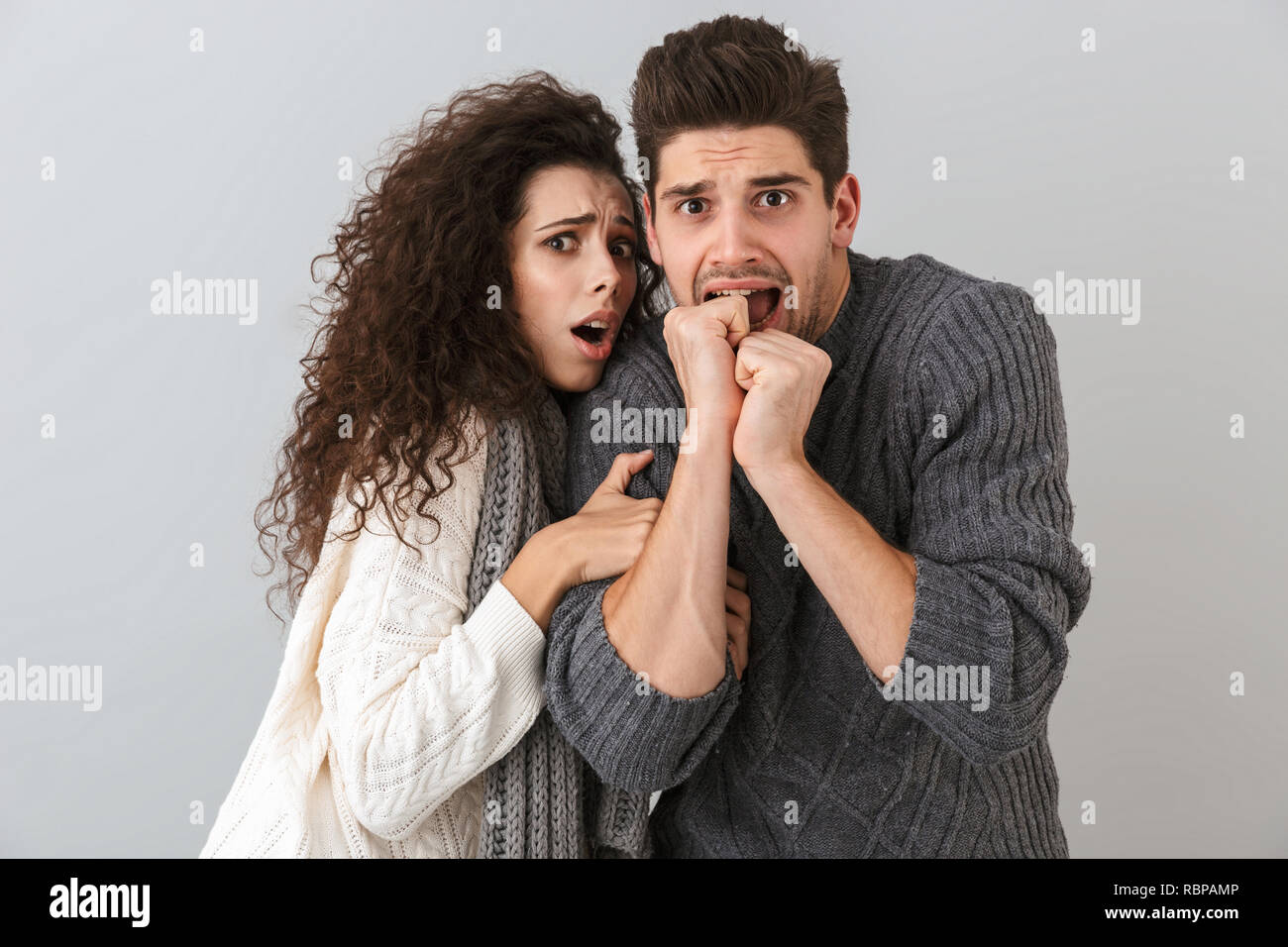 Photo of scared couple man and woman screaming and hugging in fear ...