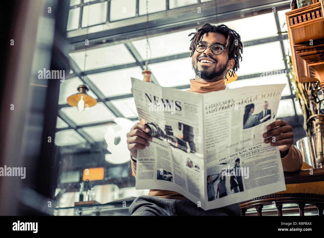 Pleased international male person doing press review Stock Photo - Alamy