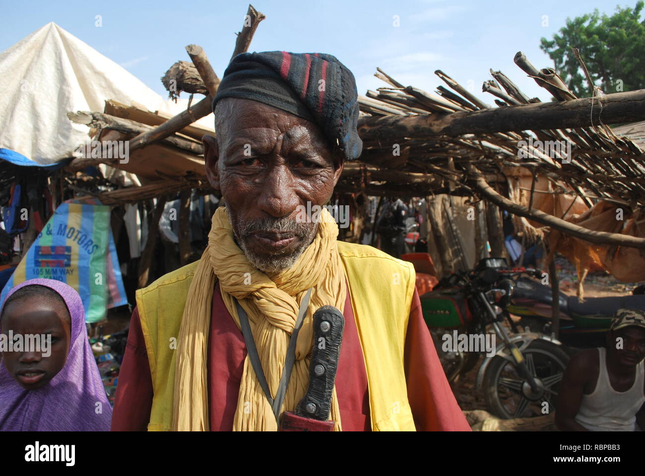An old man, armed with his knife, in a rural market in Niger, Africa ...