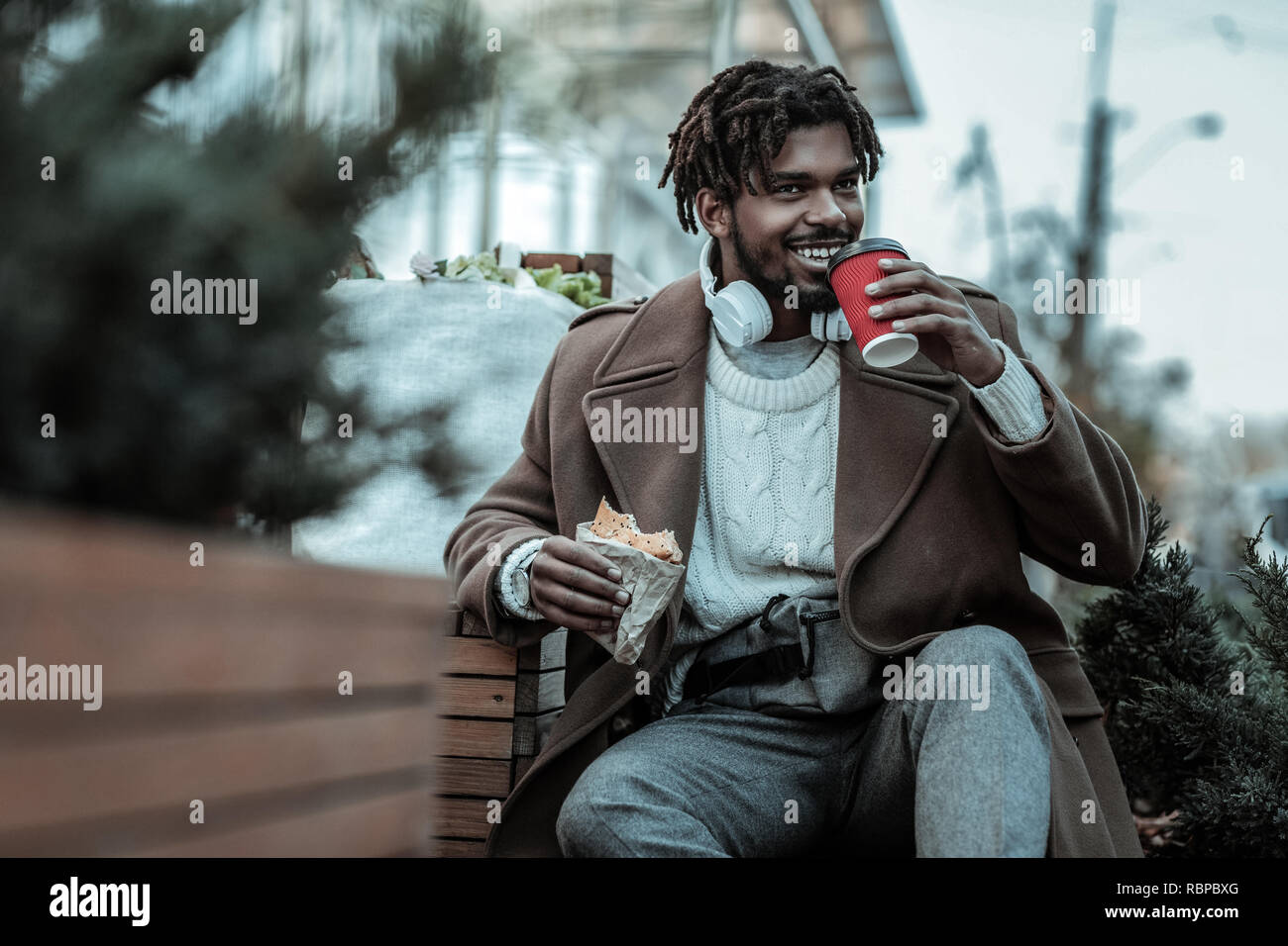 Positive delighted male person eating tasty pastry Stock Photo - Alamy