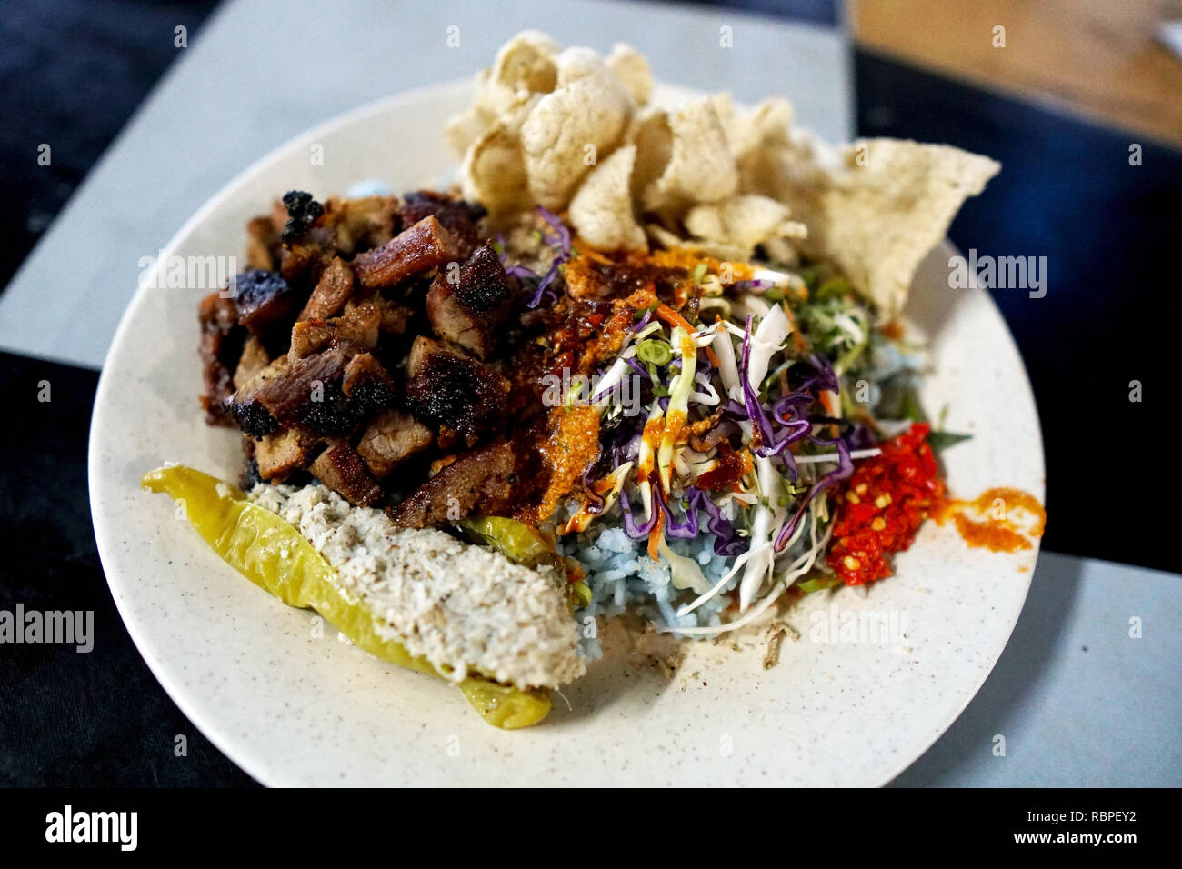 Nasi kerabu or nasi ulam, popular Malay rice dish. Blue color of rice ...