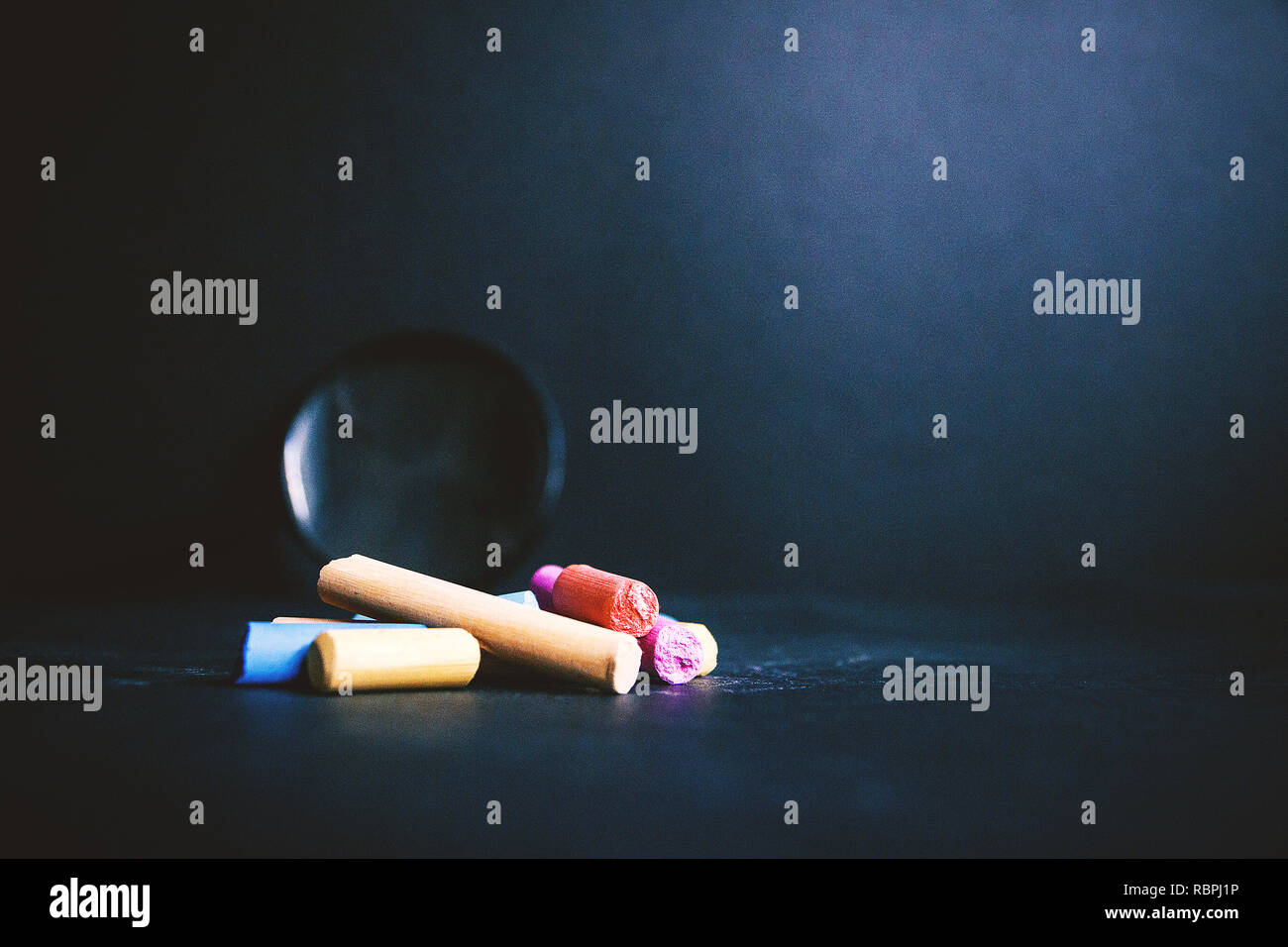 Pastel pencils pieces on a dark background random color closeup on dark ...