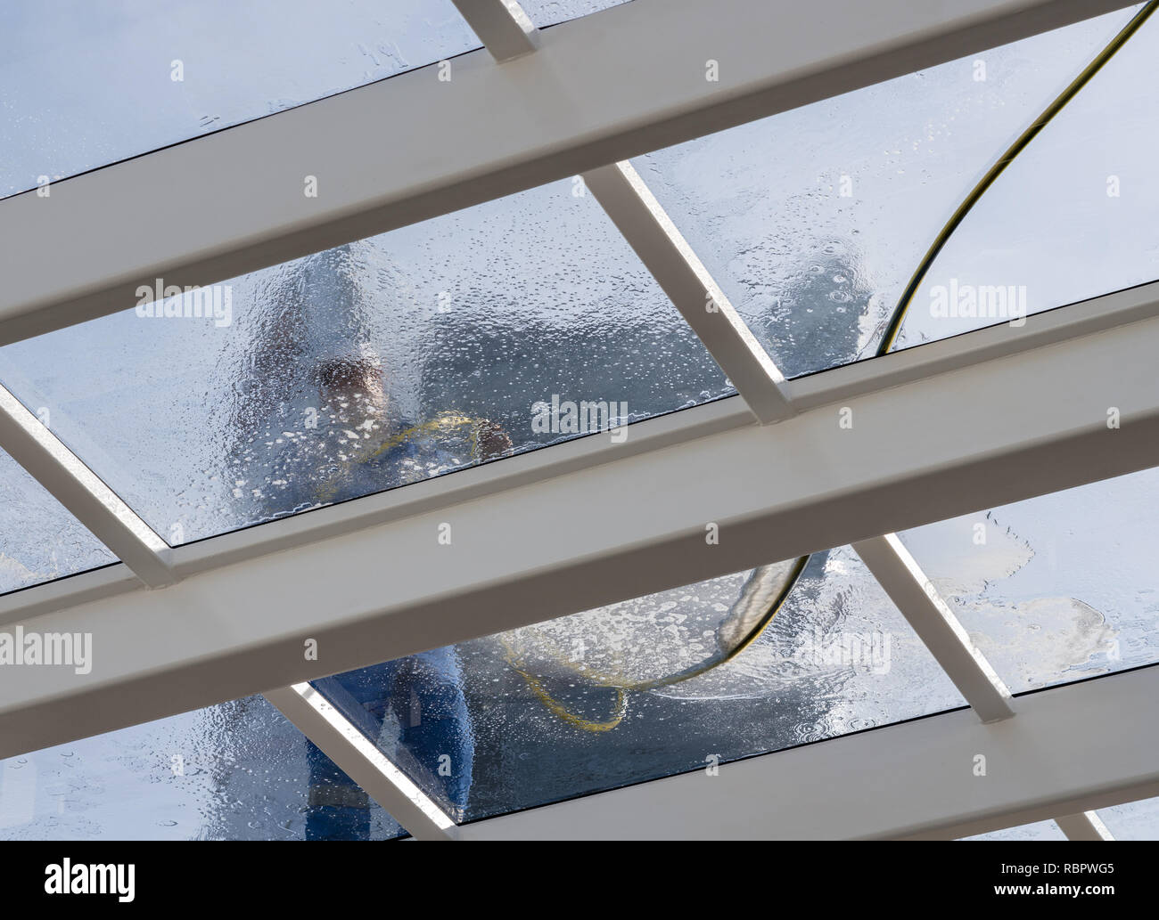 Worker cleaning large glass roof over swimming pool Stock Photo - Alamy