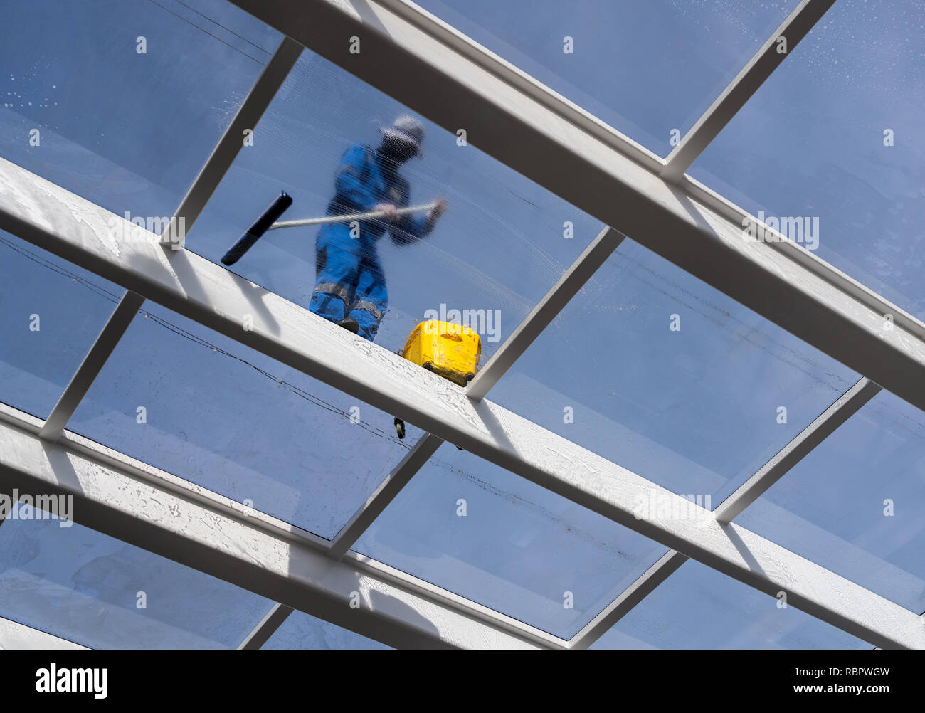 Worker cleaning large glass roof over swimming pool Stock Photo - Alamy