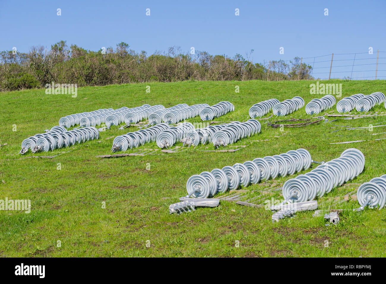 Ceramic insulators spread on a green meadow waiting to replace old ones ...