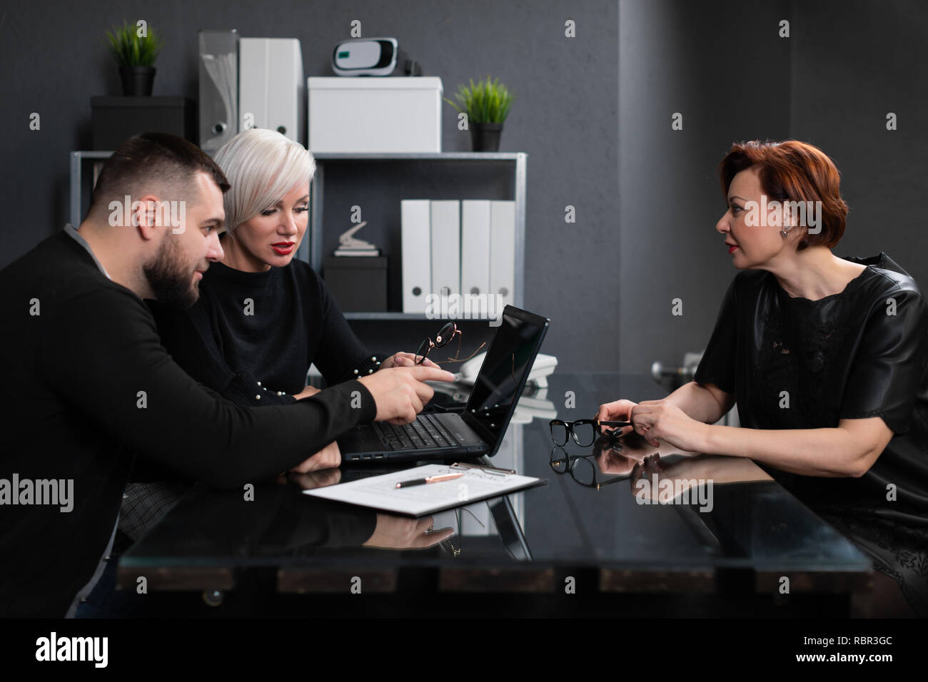 female candidate sits in front of two young men at interview Stock ...