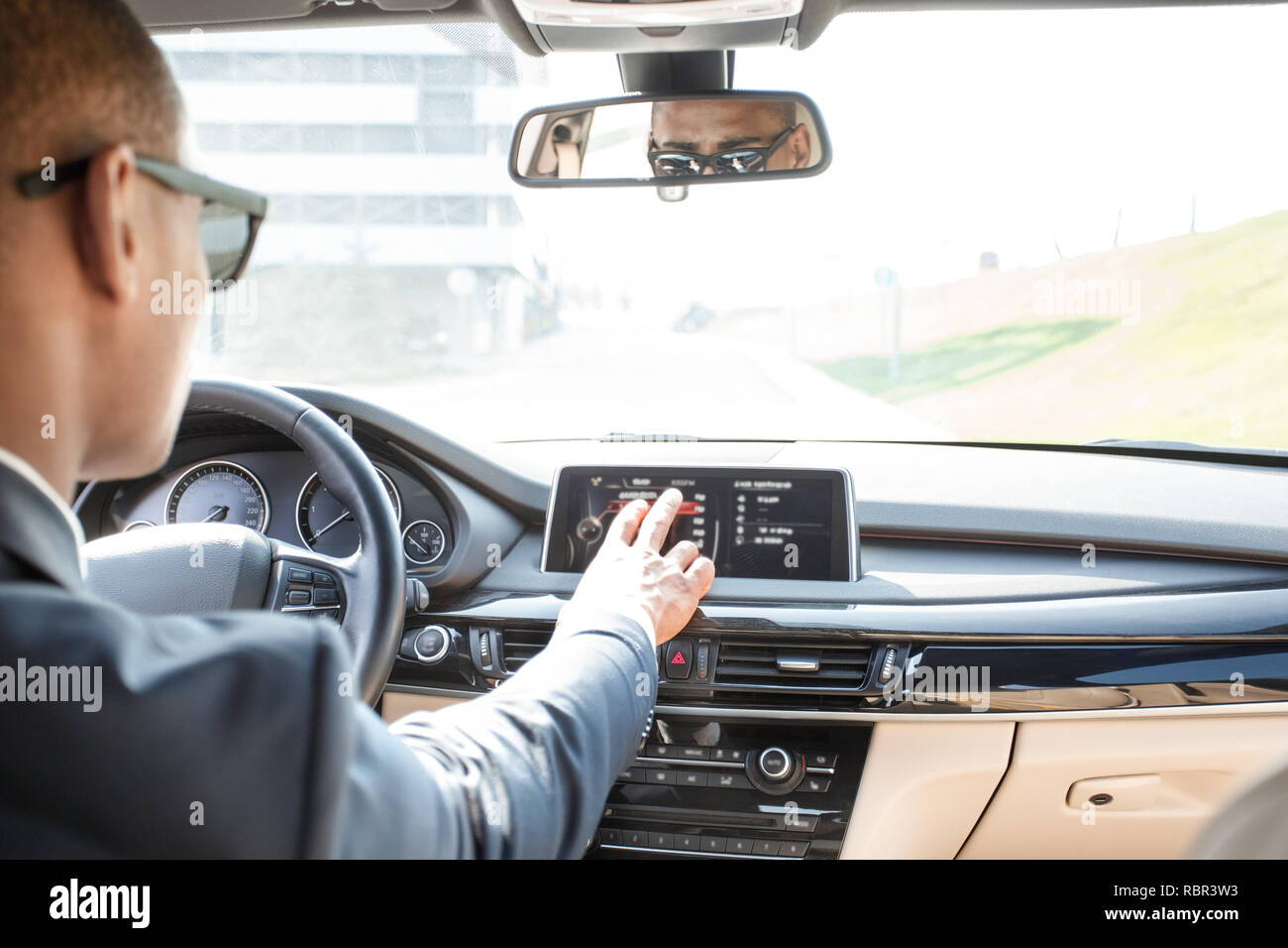 Young mulatto businessman driver wearing sunglasses sitting inside the ...