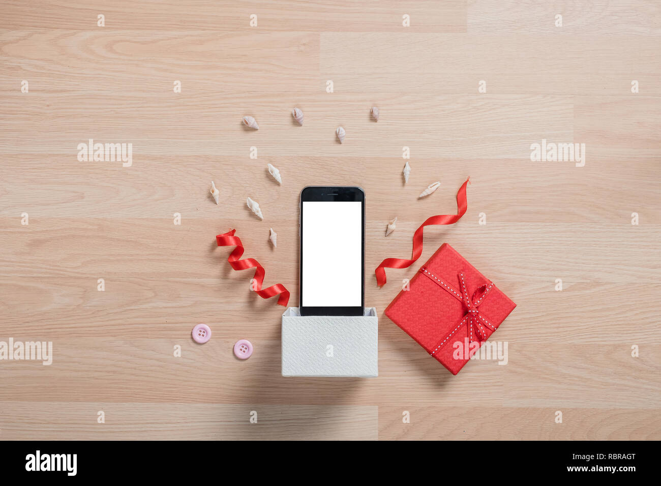 Christmas concept.Blank screen smart phone is in gift box on desk table ...