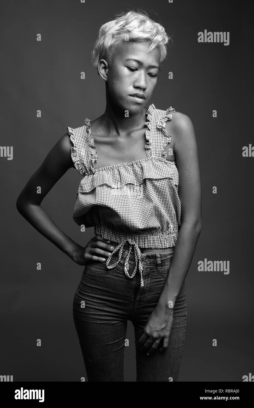 Young beautiful rebellious woman with short hair against gray ba Stock ...