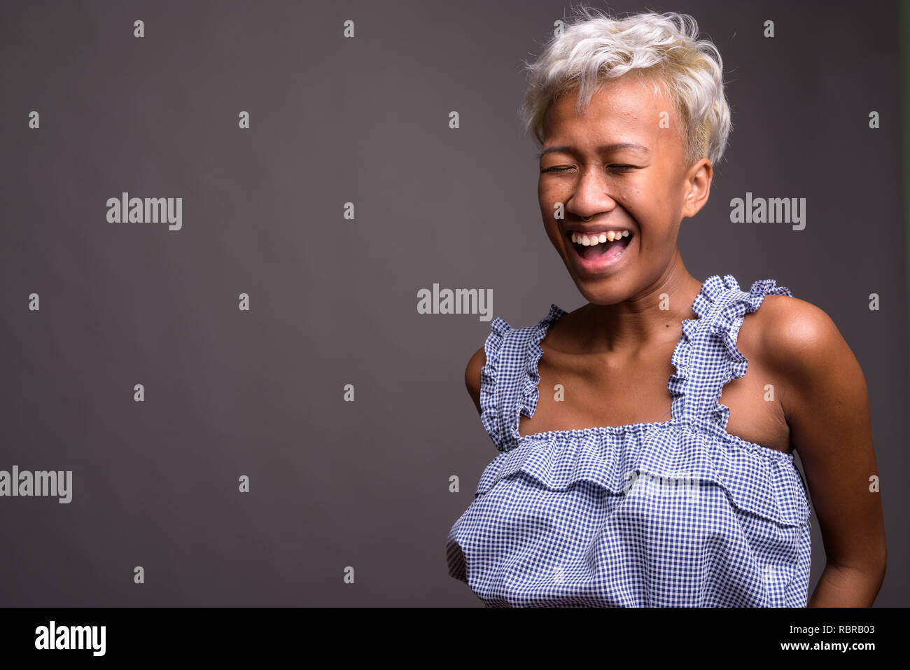 Young beautiful rebellious woman with short hair laughing Stock Photo ...