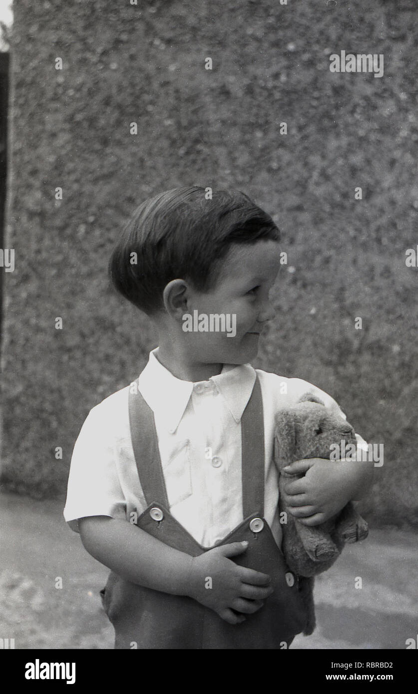 1950s, historical, 'cheeky chappy'...a young boy with his teddy bear ...