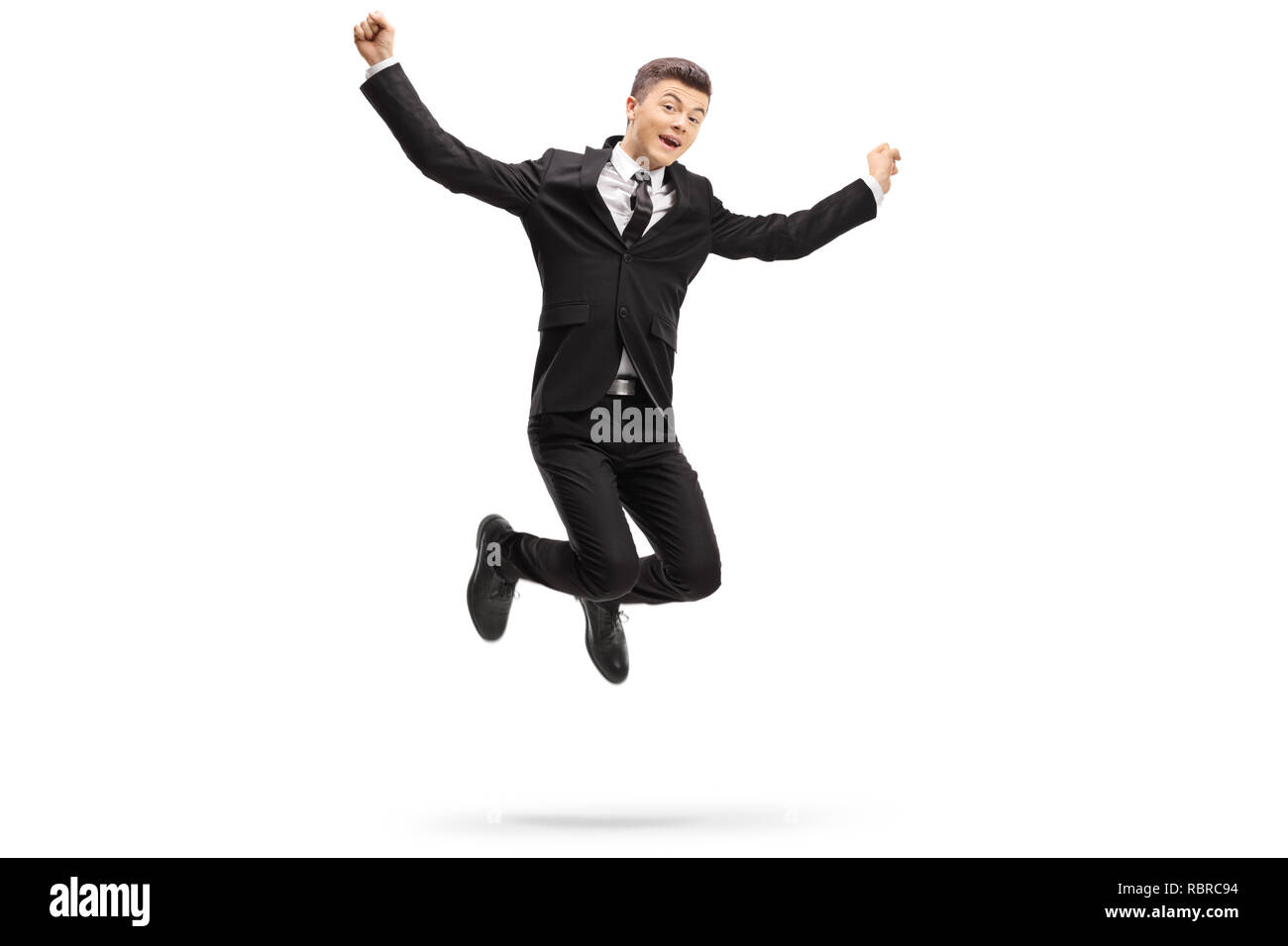 Full length portrait of an elegant young man in a suit jumping isolated ...