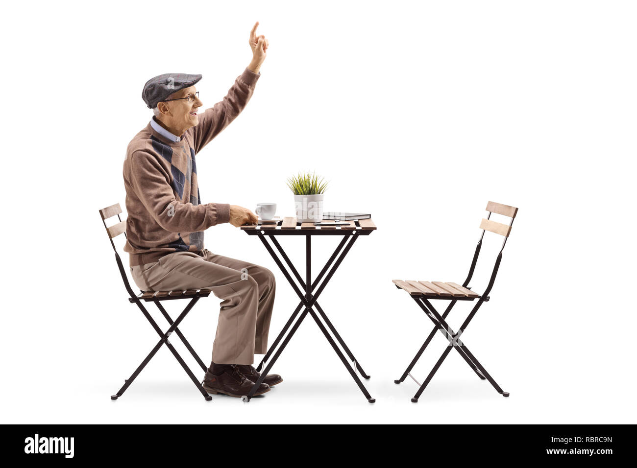Full length profile of an elderly man sitting at a coffee table and ...