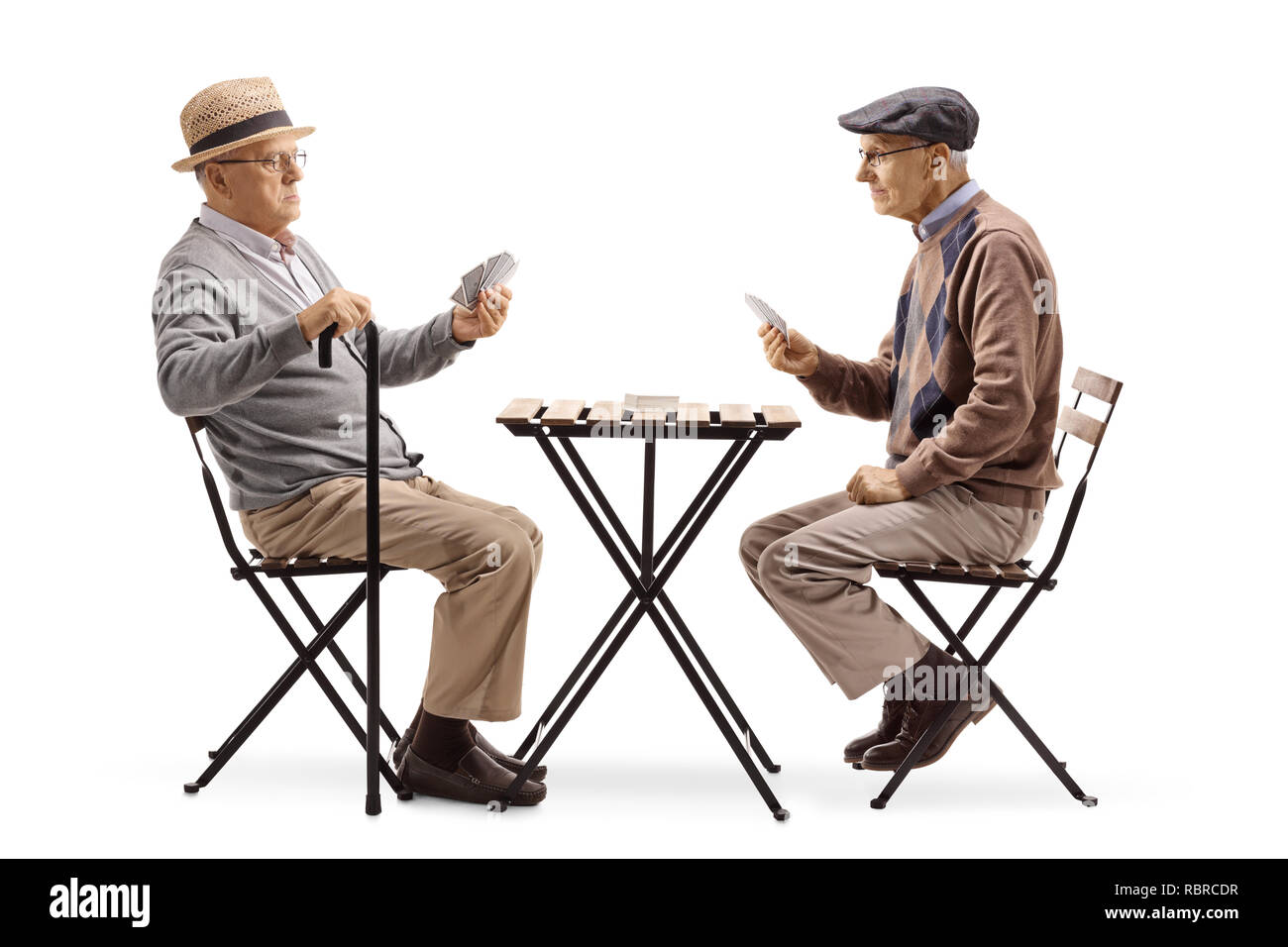 Full length shot of two senior men playing cards at a table isolated on ...