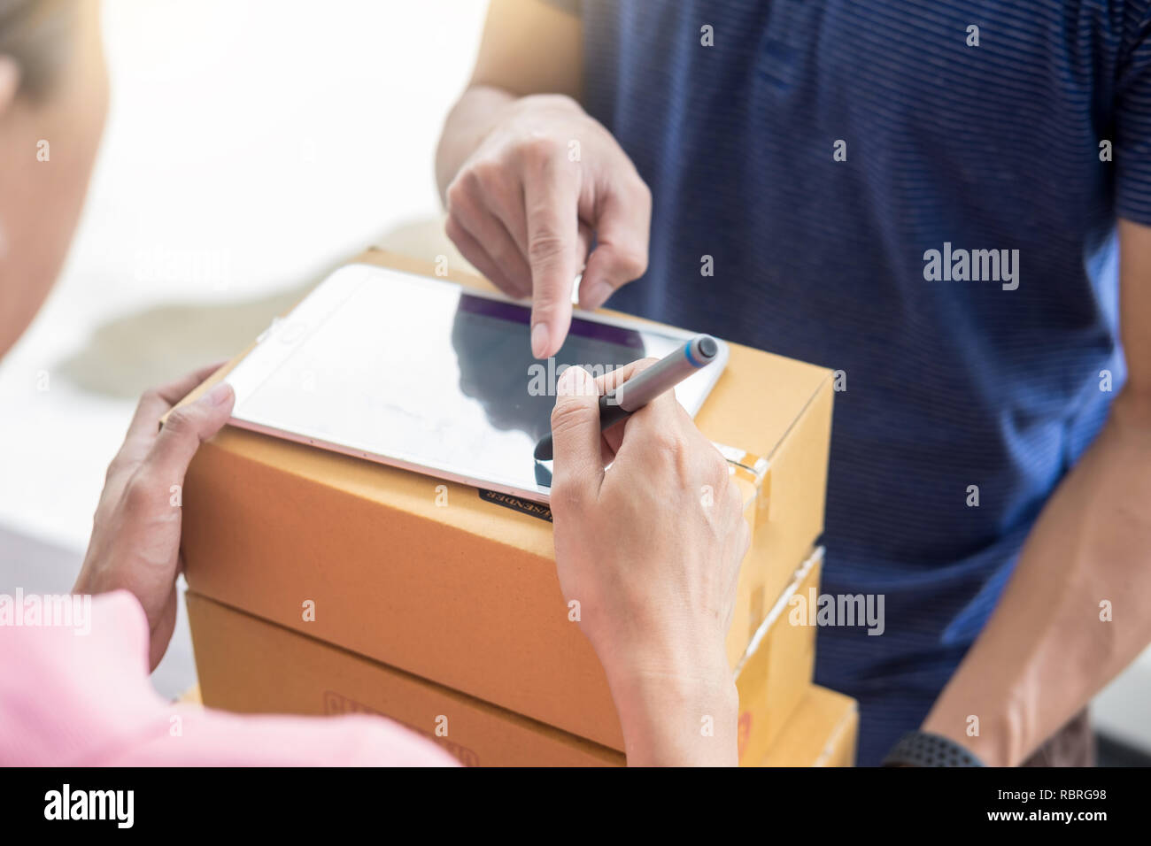 woman courier holding a parcel Shipping Mail appending signature ...