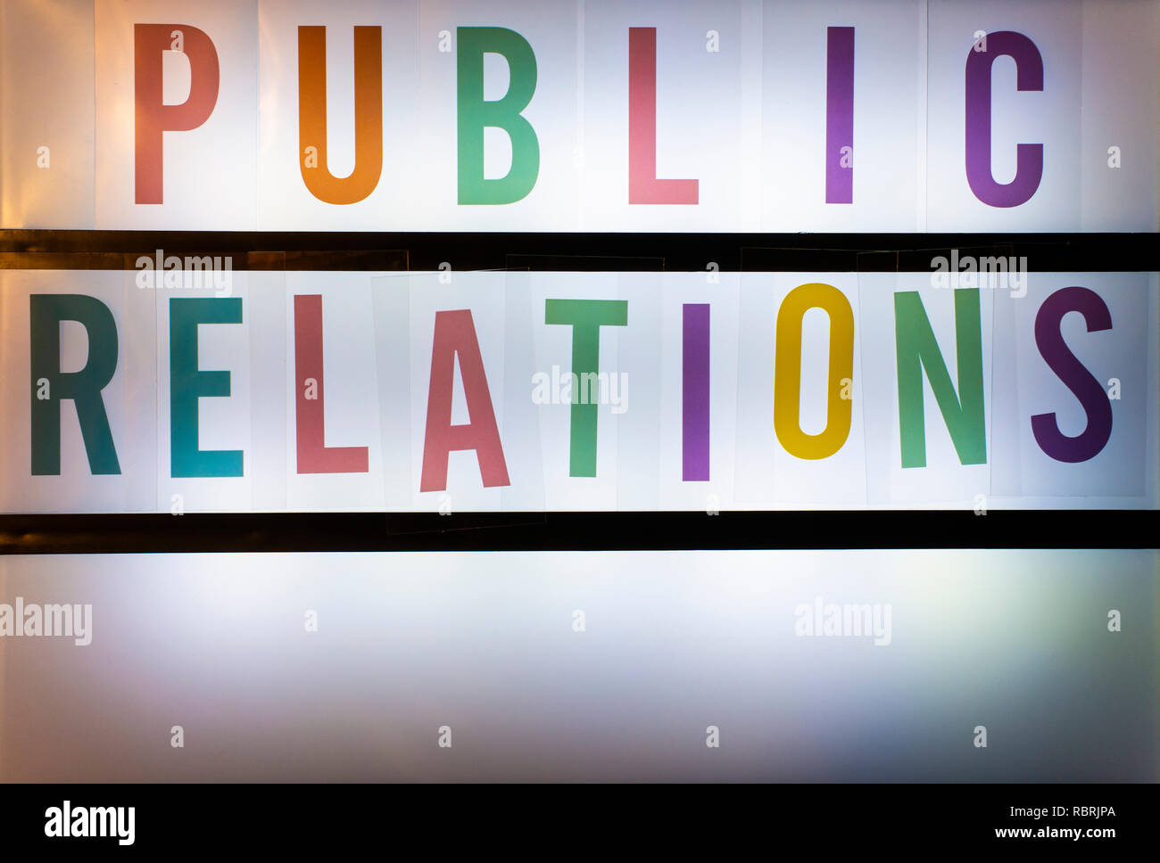 Public Relations text on backlight board. Colored Characters on white ...