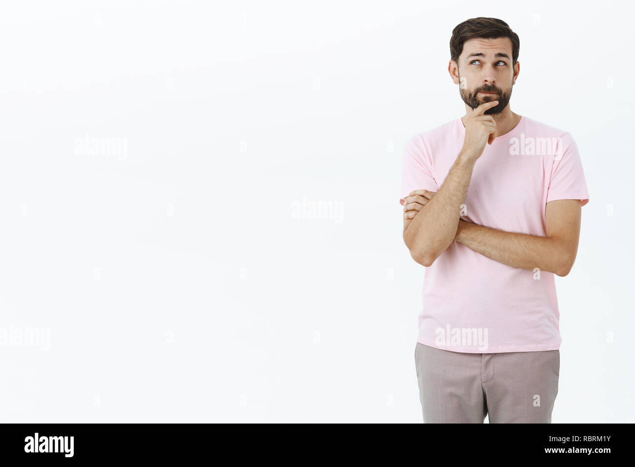 Man making up mind what order looking up with raised eyebrows touching ...