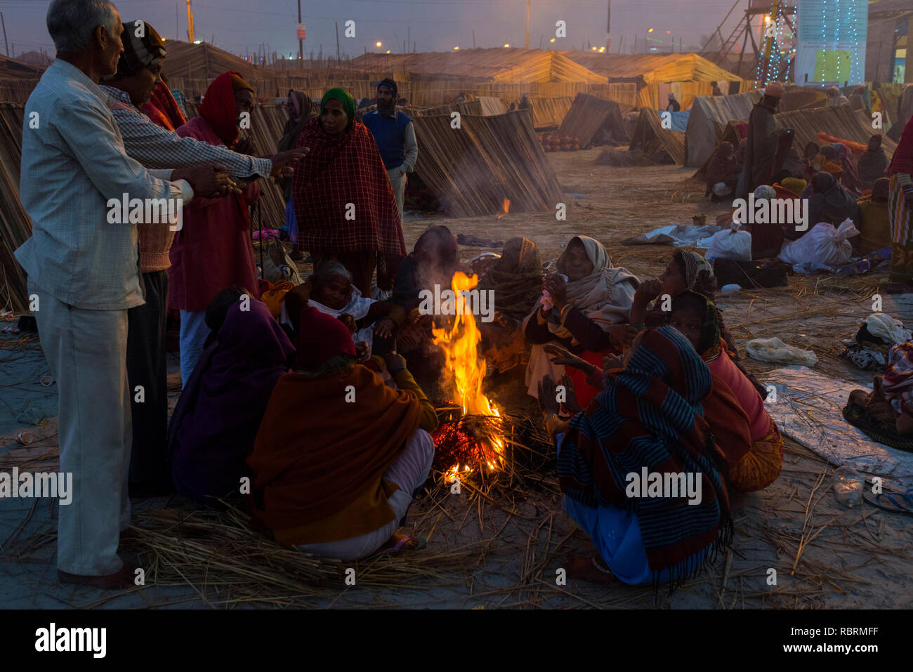 Pilgrims warm themselves gathering around fire on a winter night at ...