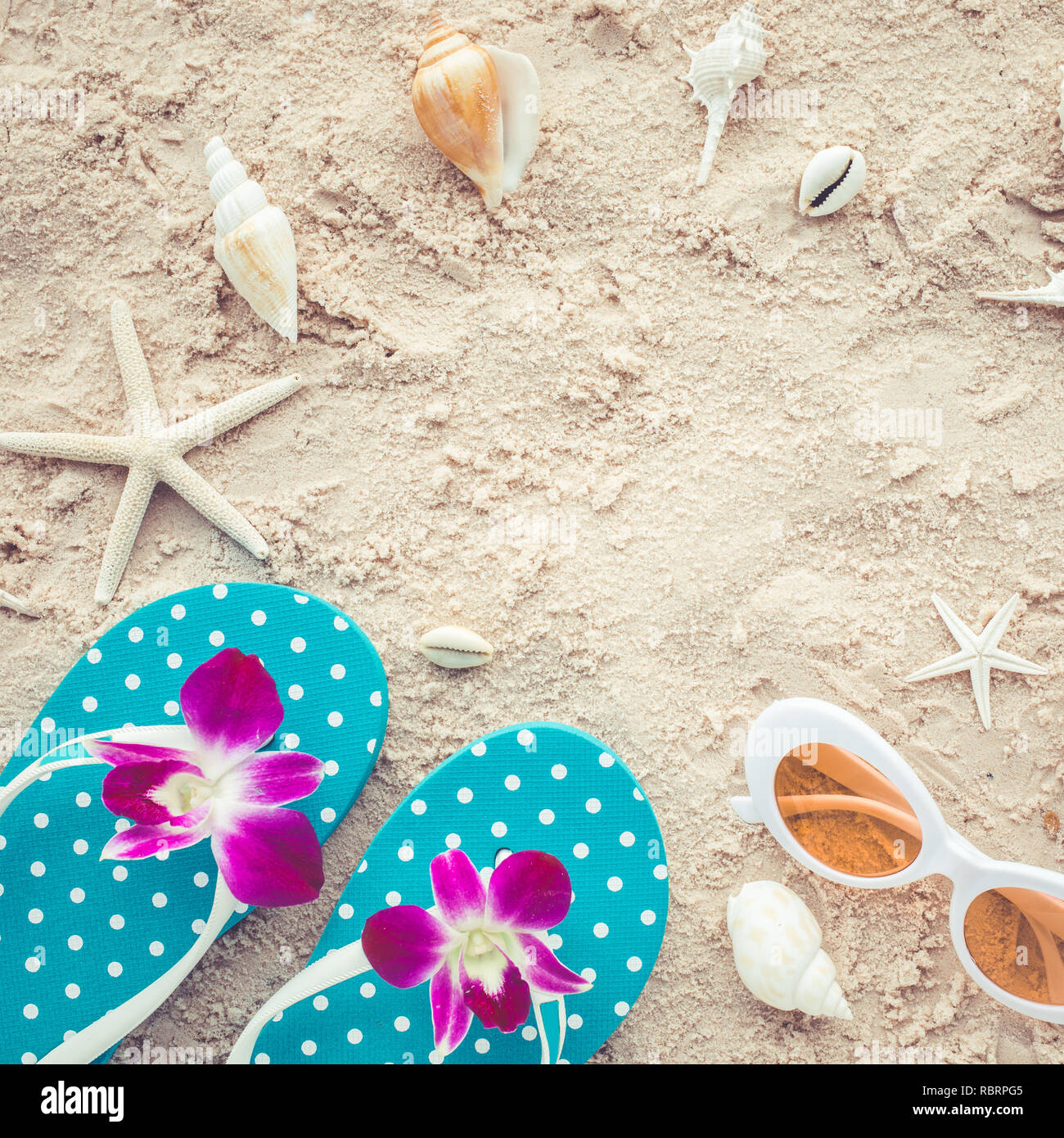 Holiday summer concept with sandals and sunglasses and shells on beach ...