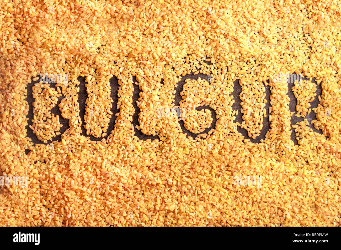 The lettering Bulgur from the grains of bulgur whrat on a black ...