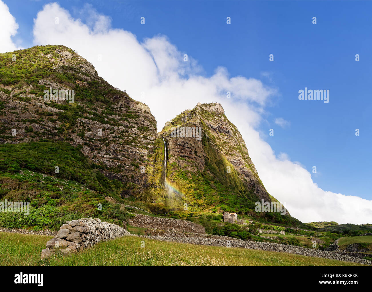 Big waterfall with rainbow on the Azores island Flores, steep imposing ...