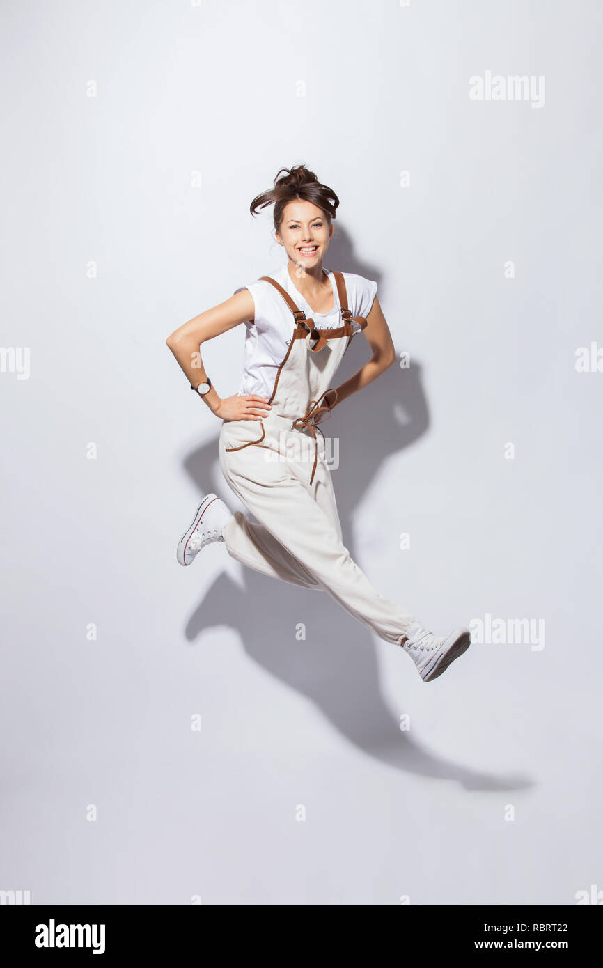 Full length portrait of a cheerful young woman jumping and celebrating ...